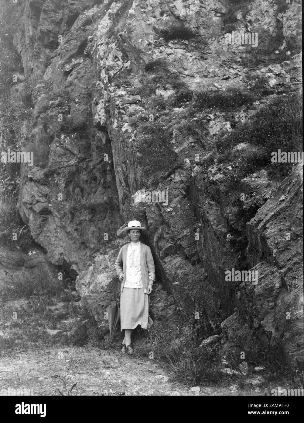 Archive image circa 1920 of as lady standing in front of a granite ...