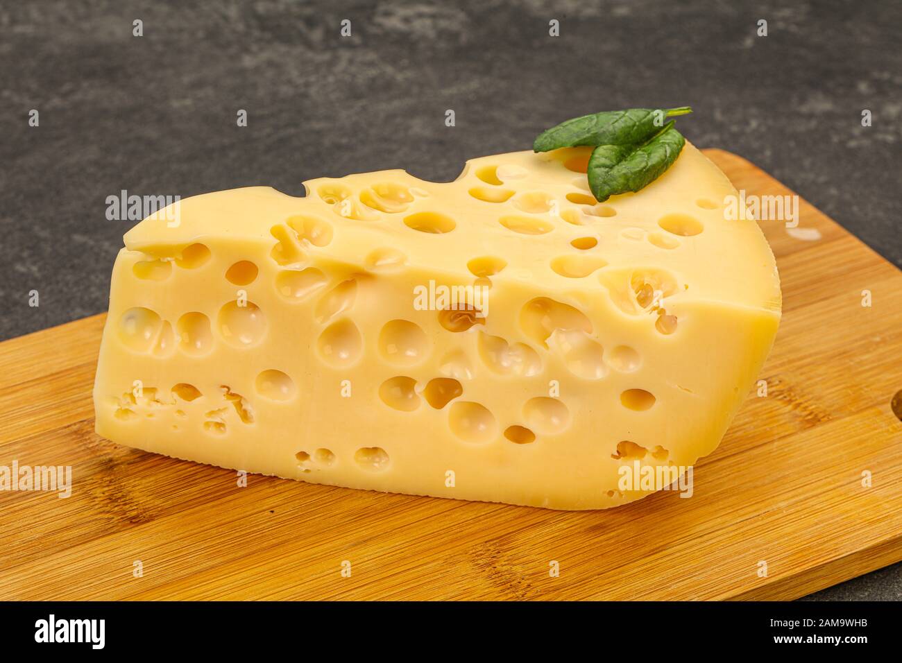 Maasdam cheese - dairy yellow triangle with holes Stock Photo - Alamy