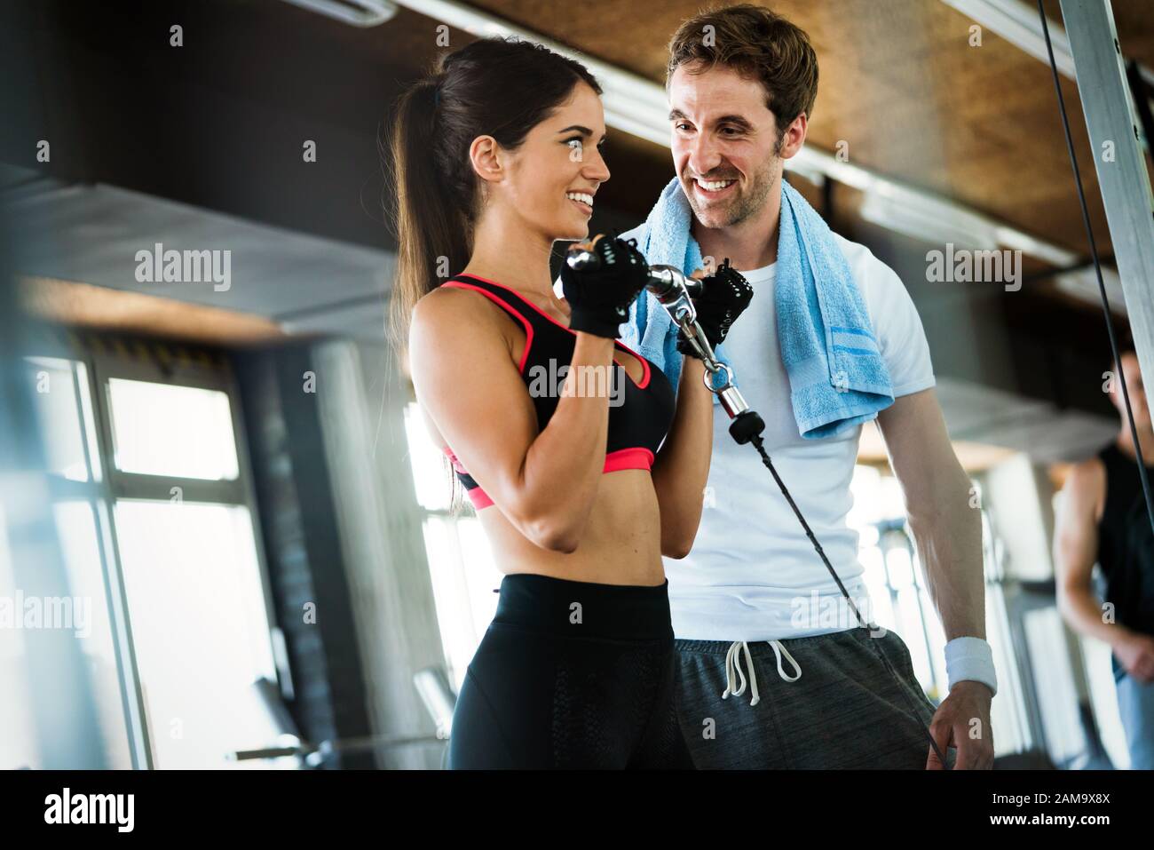 Personal trainer giving instructions a woman in gym Stock Photo - Alamy