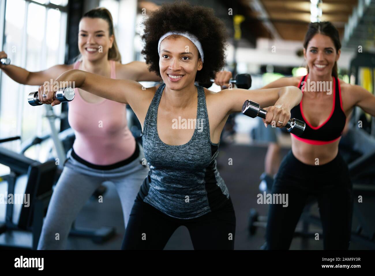 Beautiful fit people exercising together in gym Stock Photo - Alamy