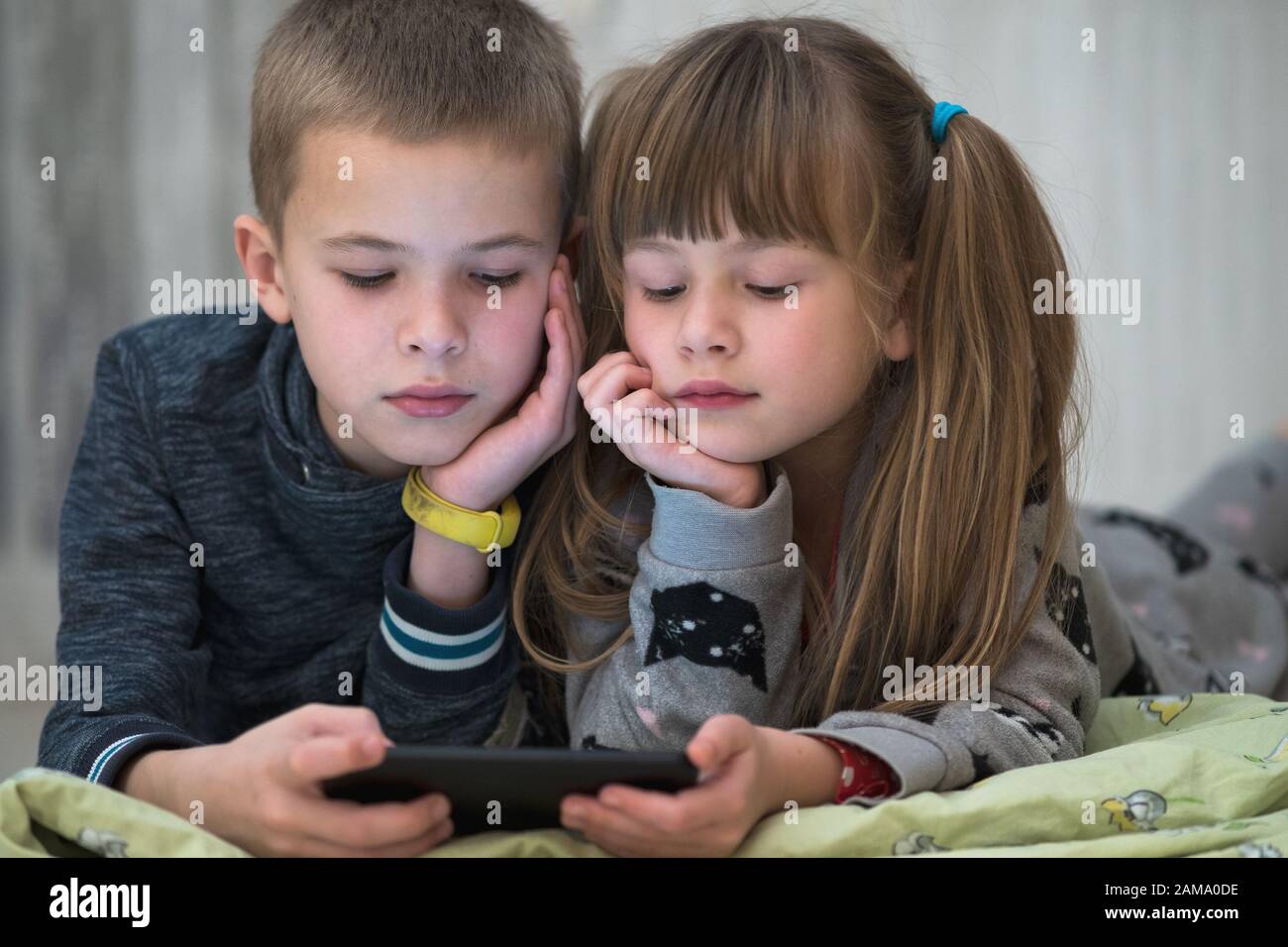 Two children brother and sister watching video on smartphone screen ...