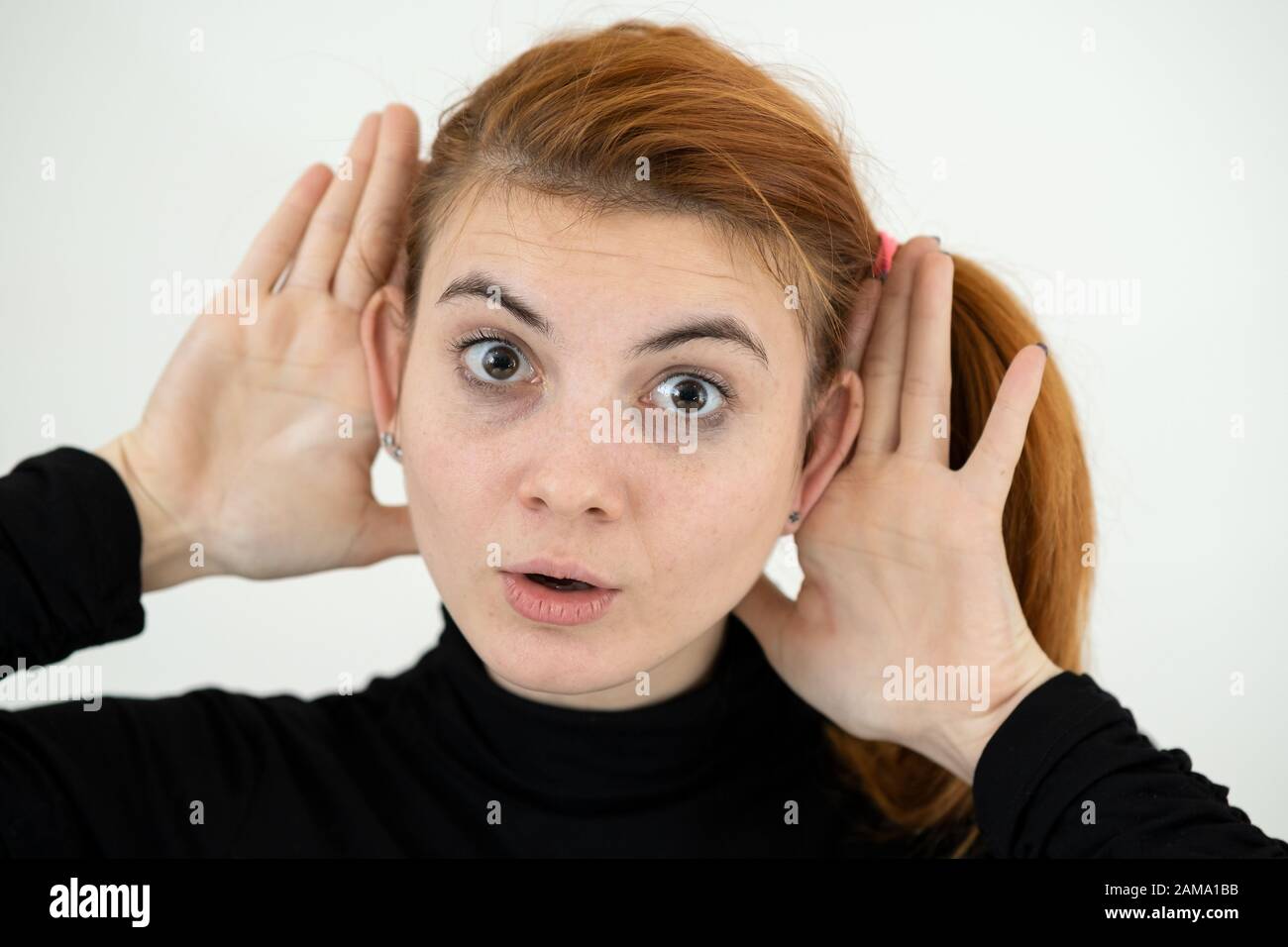 Close up portrait of funny girl holding her ears with hands like a ...