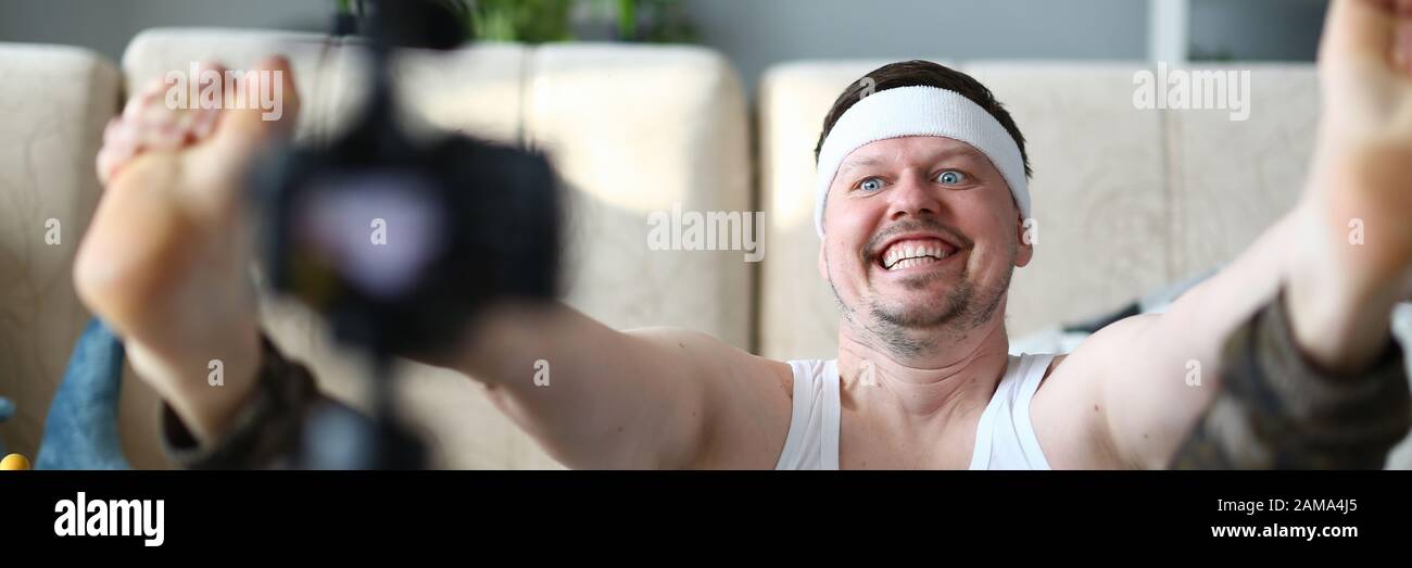 Happy Man Recording Exercise for Legs on Camera Stock Photo - Alamy