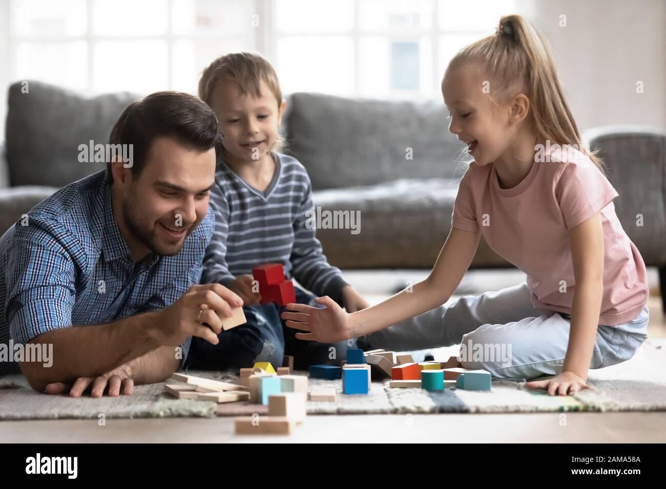 Young dad playing with kids building with bricks Stock Photo - Alamy