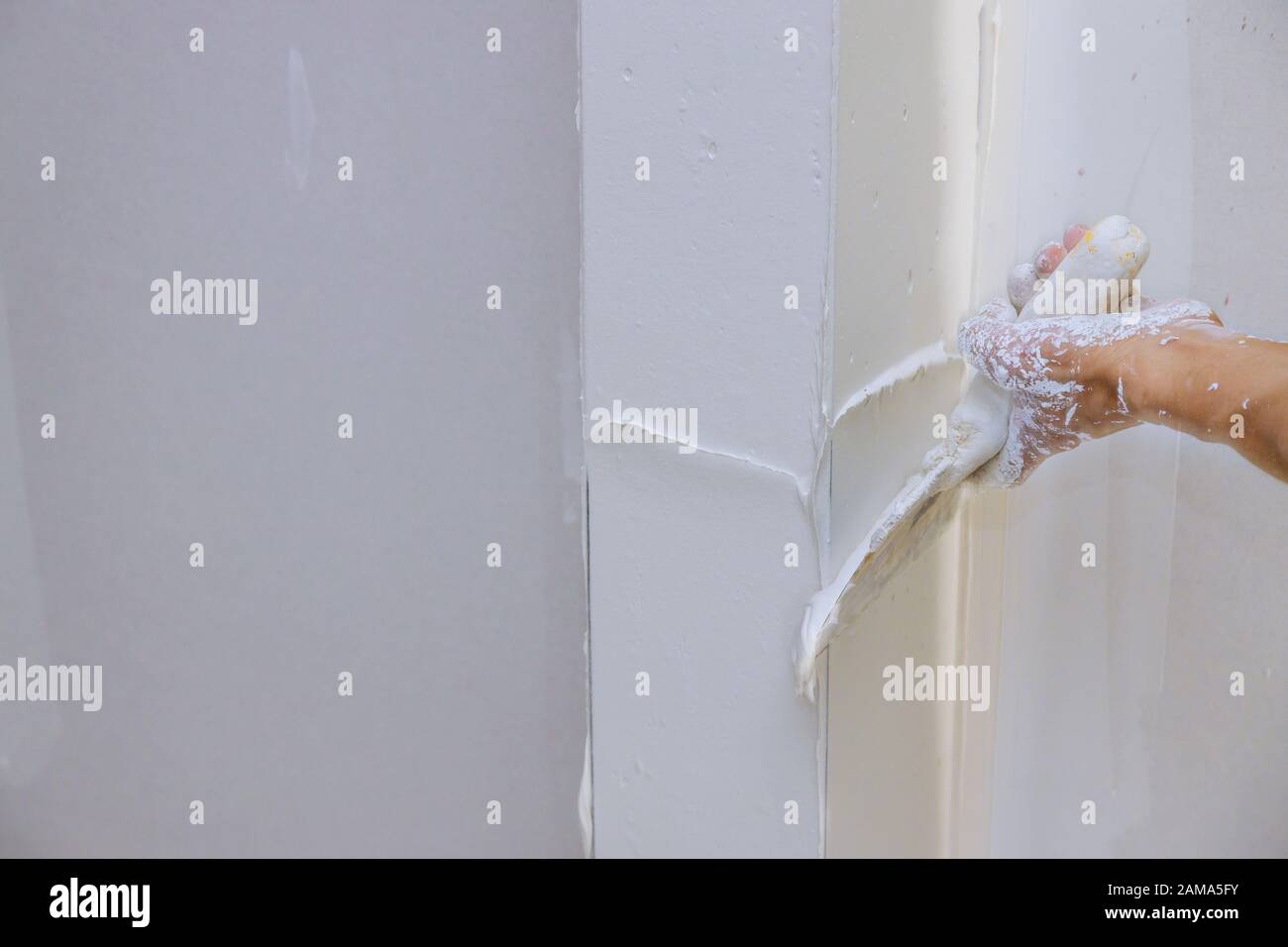 Renovation the wall with putty spreading plaster on wall Stock Photo ...
