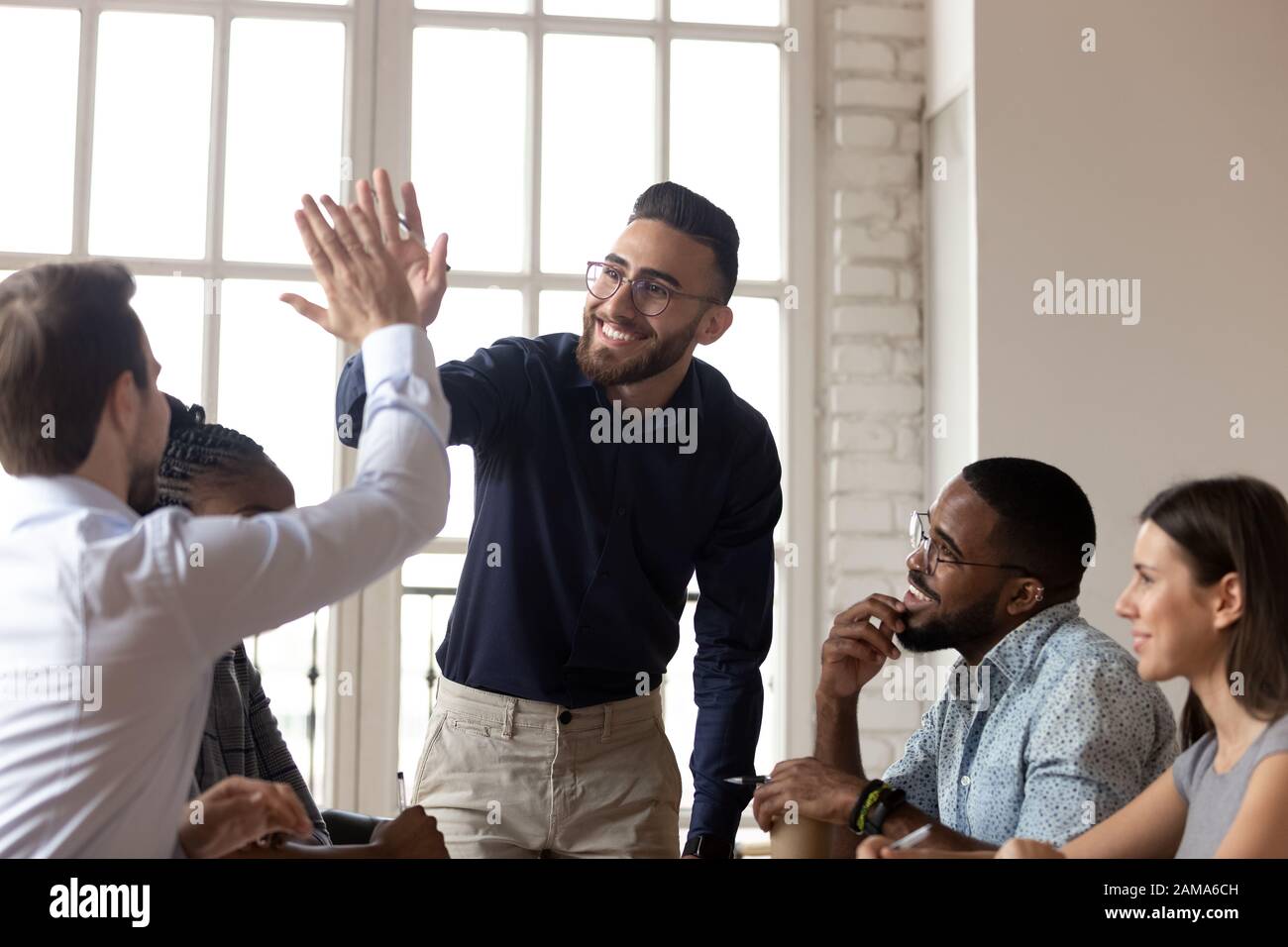 Smiling multiethnic male colleagues celebrate shared success Stock ...