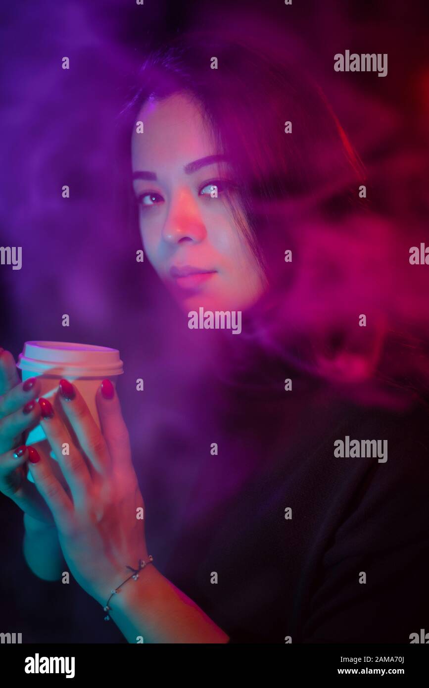 The girl is drinking coffee. Neon light Stock Photo - Alamy
