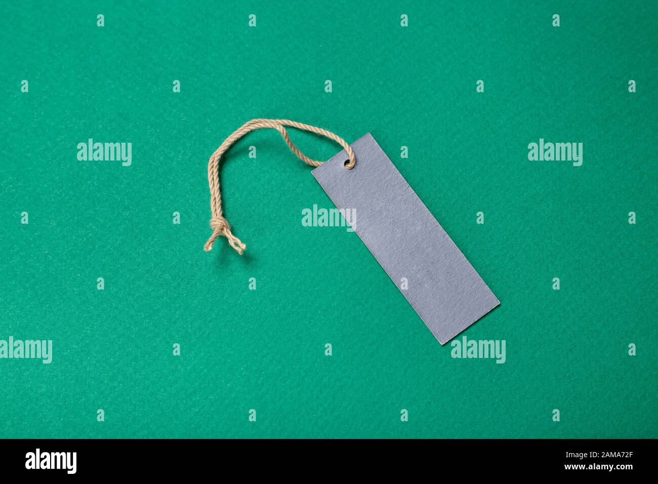 cardboard label with a string. without inscriptions. on a green ...