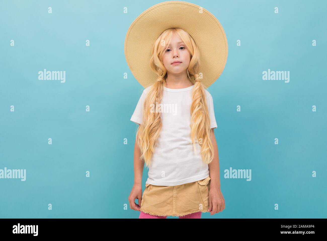 A little beautiful girl with long blonde hair braided in tails in big ...