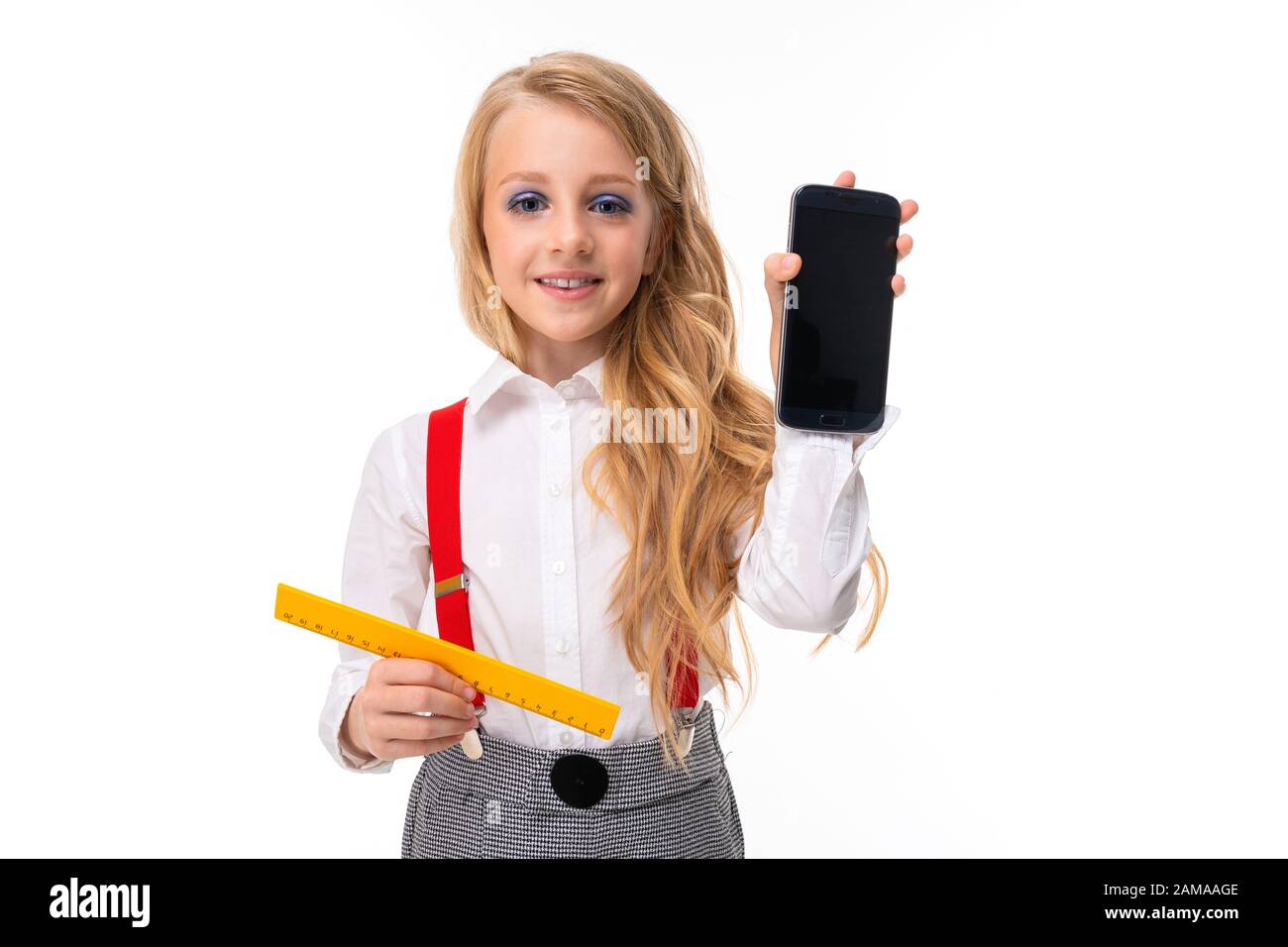 Pretty caucasian girl with long blonde hair holds a ruler and mobile ...