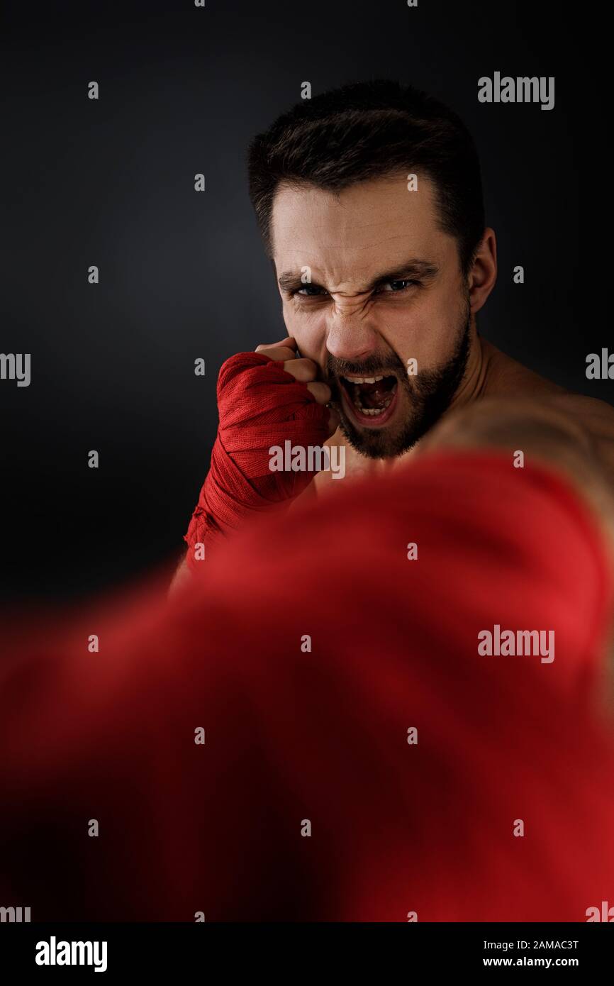 Sportsman boxer throwing a fierce and powerful punch forward in the ...