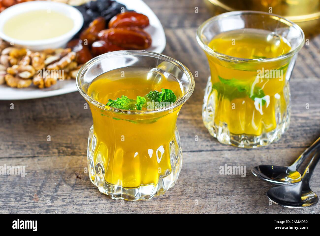 Oriental tea with mint, honey, nuts and dried fruits on wooden table ...