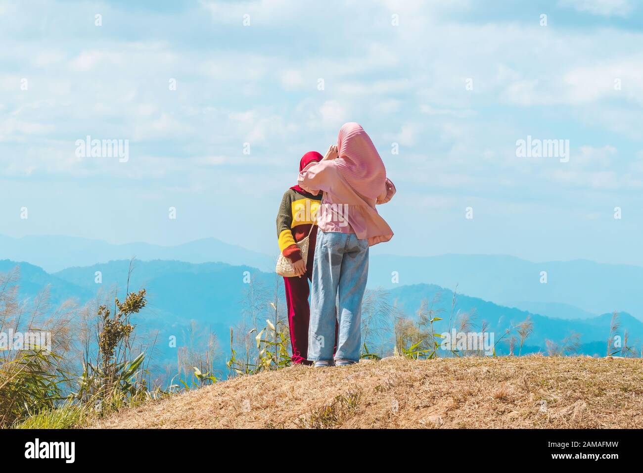 Back view of Muslim women wearing a Muslim dress and hijab enjoy on the ...
