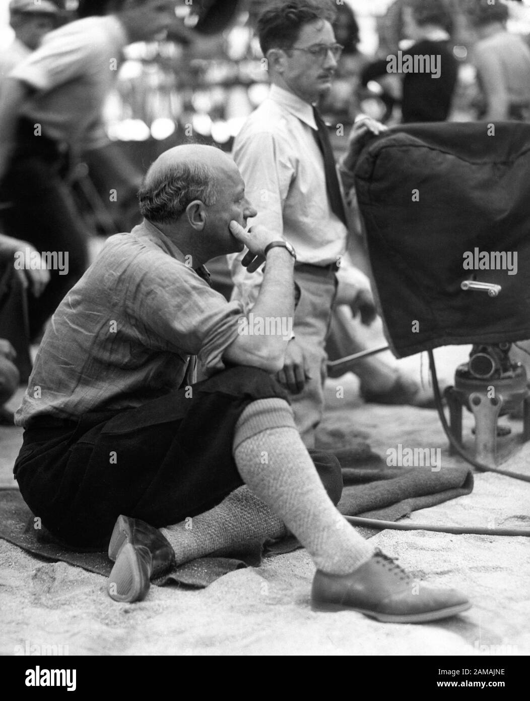 Director CECIL B. DeMILLE on set candid filming with film crew on ...