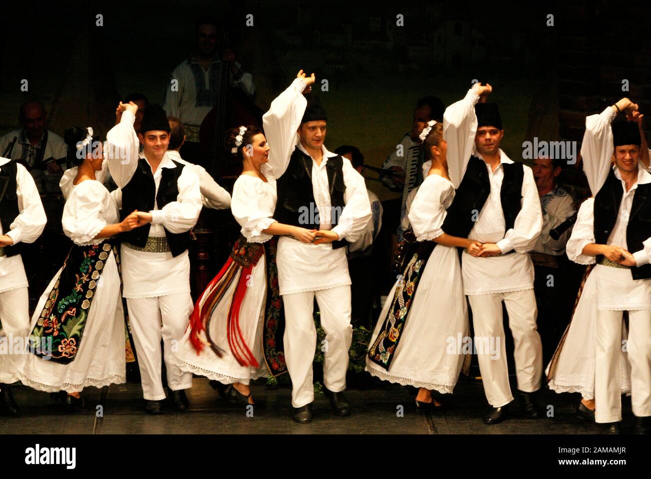 Professional dancers of the Banatul Folklore Ensemble hold hands in a ...