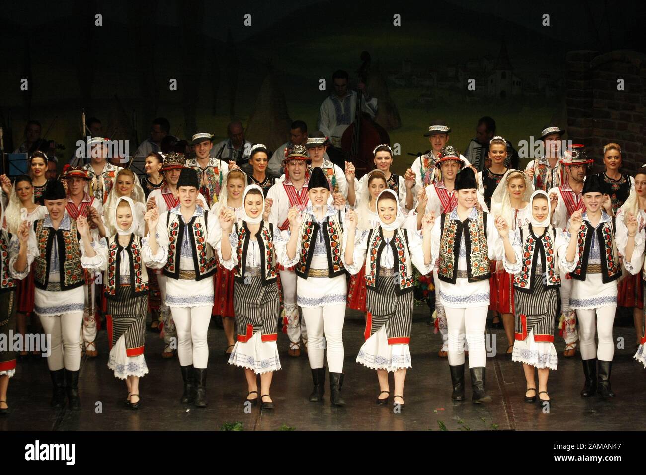 Professional dancers of the Banatul Folklore Ensemble hold hands in a ...