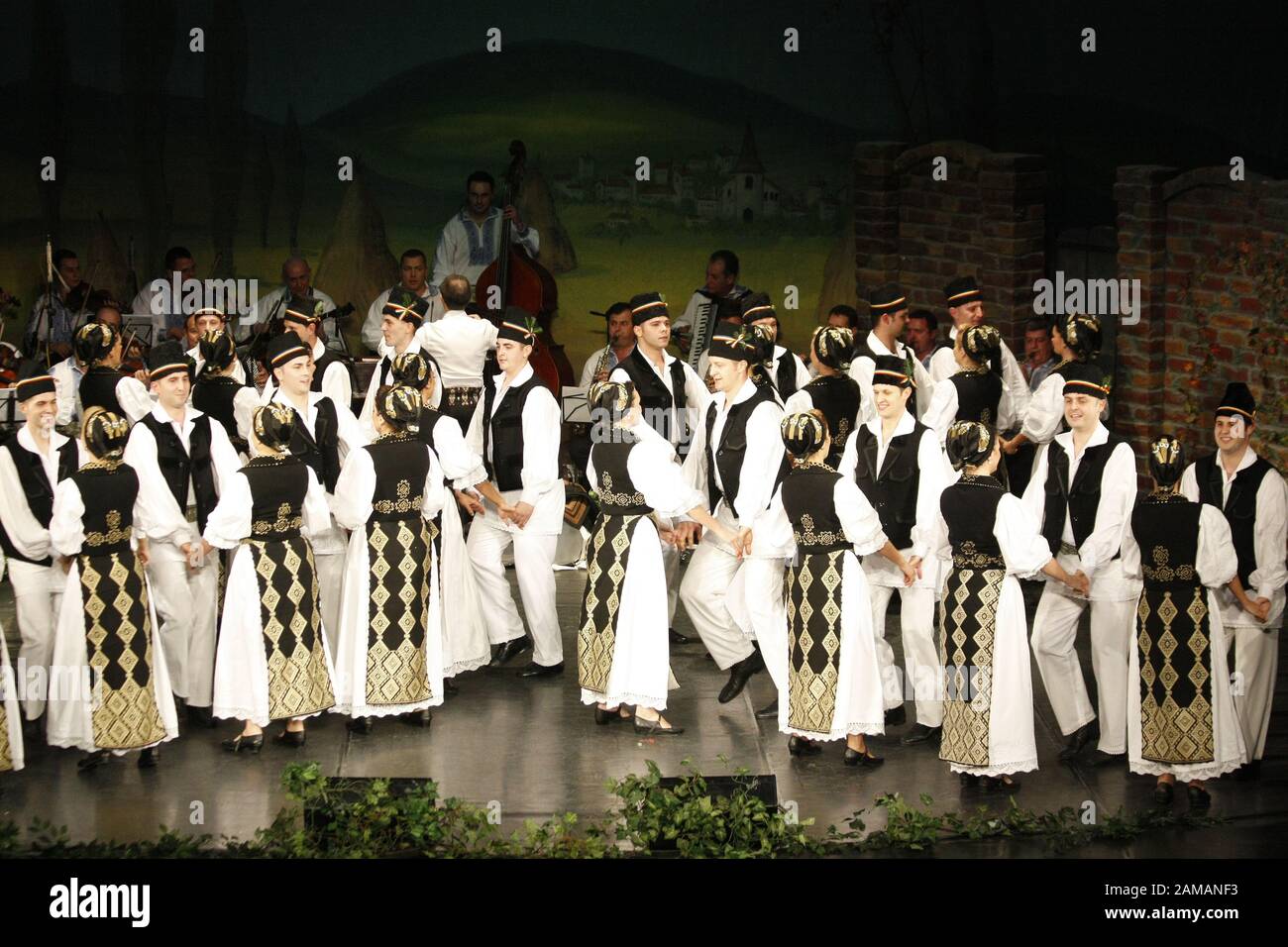 Professional dancers of the Banatul Folklore Ensemble hold hands in a ...