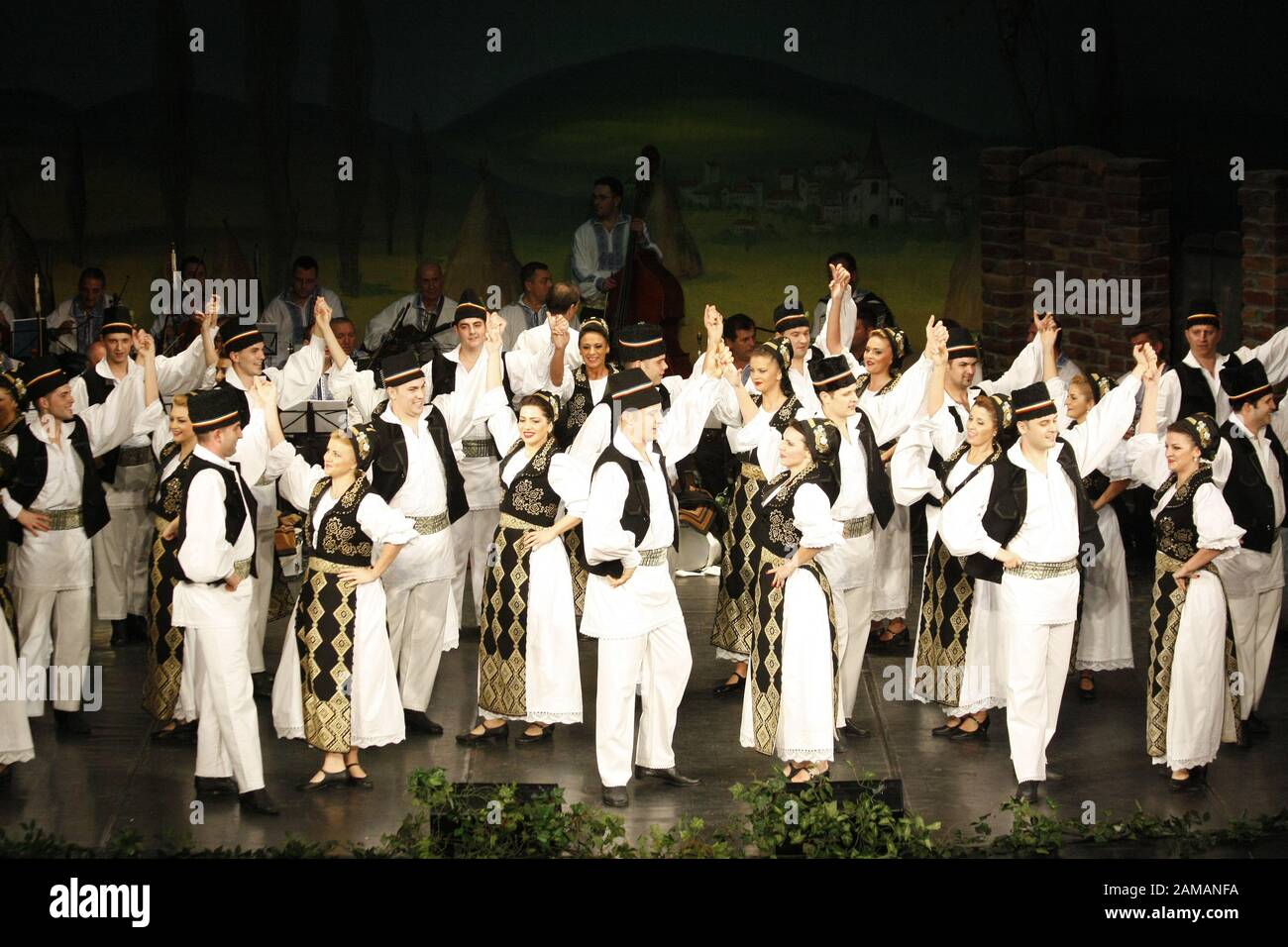 Professional dancers of the Banatul Folklore Ensemble hold hands in a ...