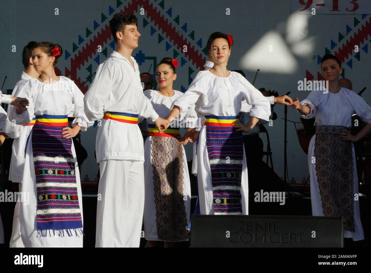Professional dancers of the Banatul Folklore Ensemble hold hands in a ...
