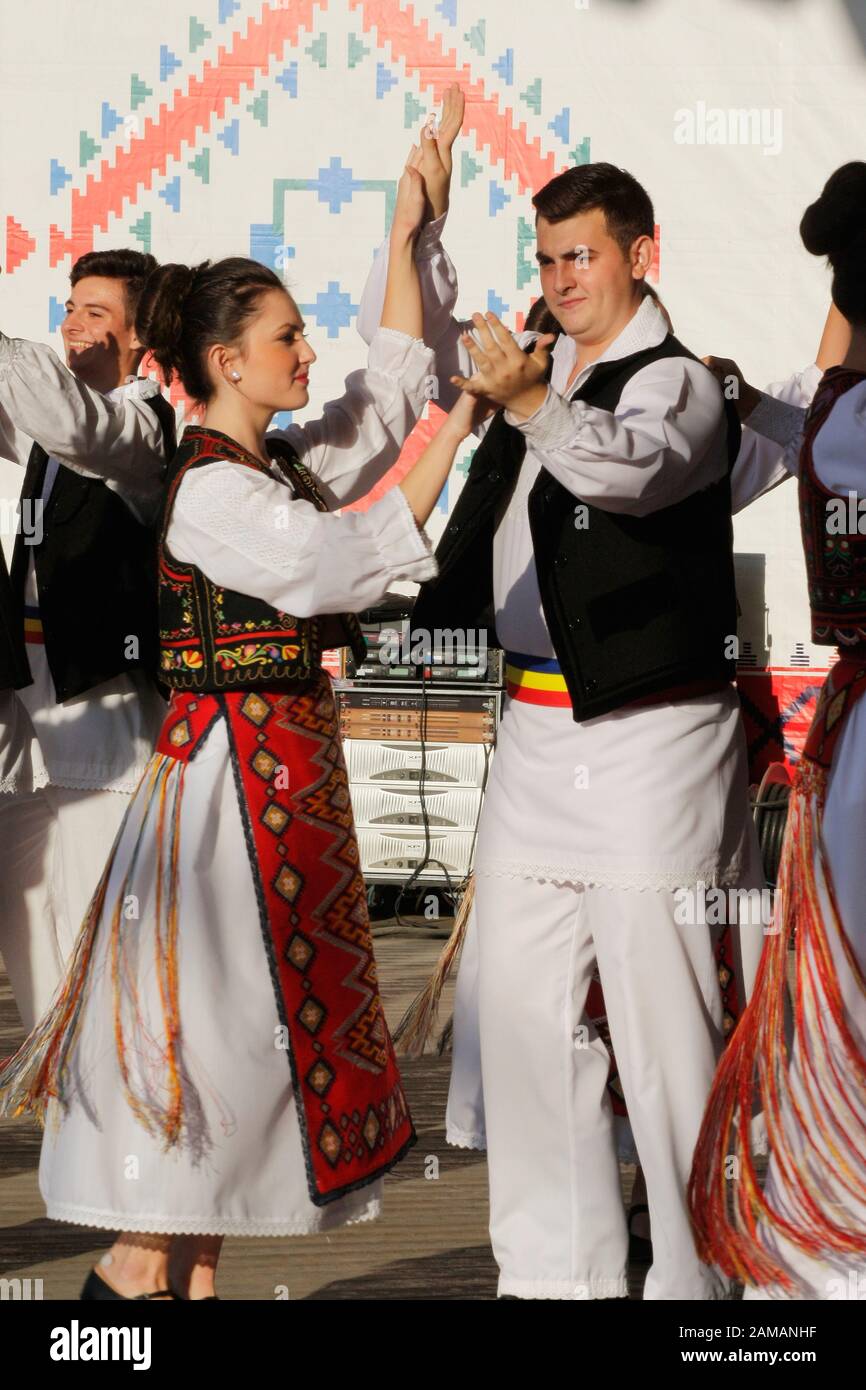 Professional dancers of the Banatul Folklore Ensemble hold hands in a ...