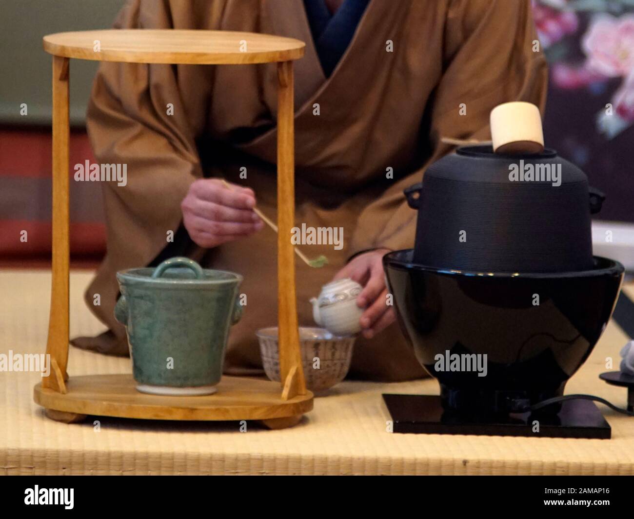Japanese tea ceremony Chanoyu. Man dressed in traditional kimono scoops ...