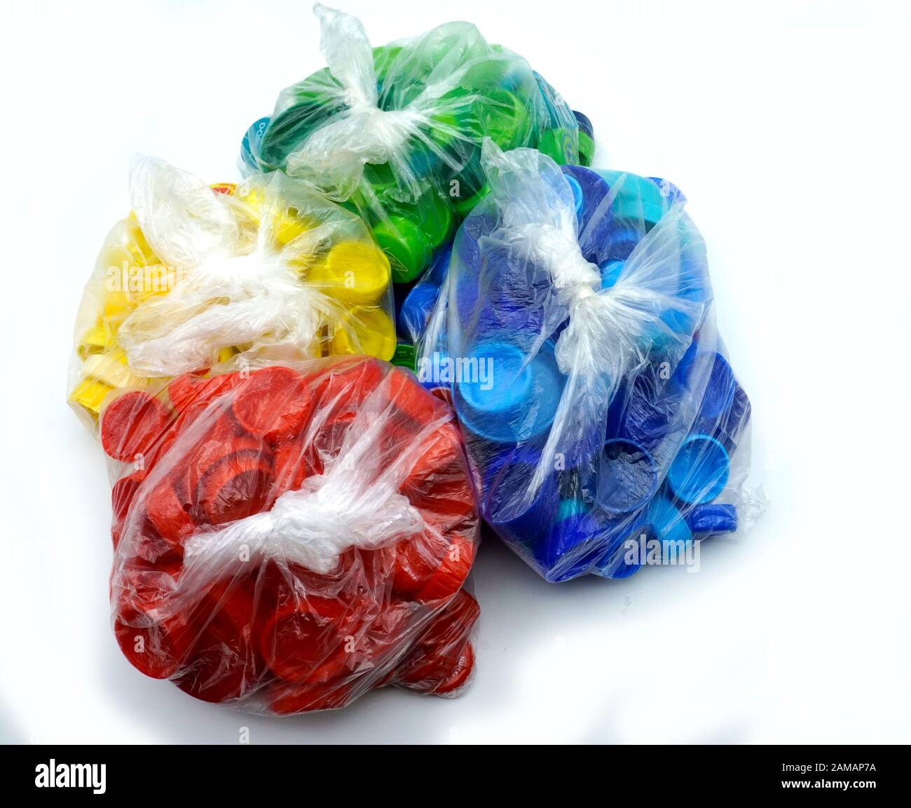 Colorful plastic bottle caps sorted by colors in transparent single use ...