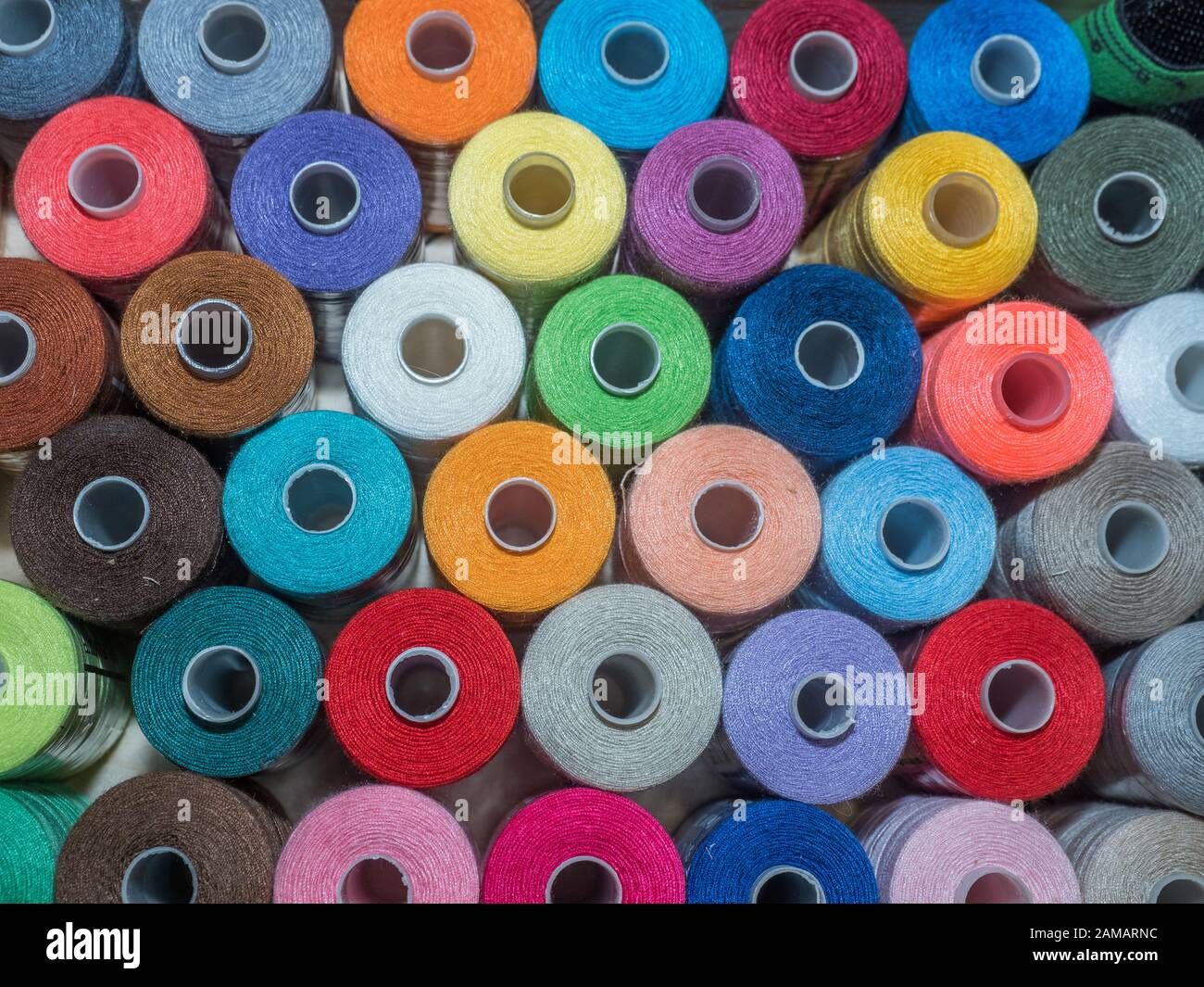 A lot of sewing colored thread. Thread reels. Colorful threads in the ...