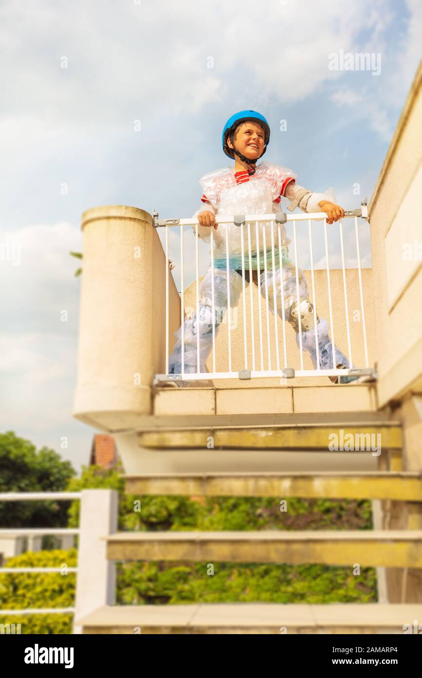Boy stand near kids safe door, stairs in bubble wrap and helmet from ...