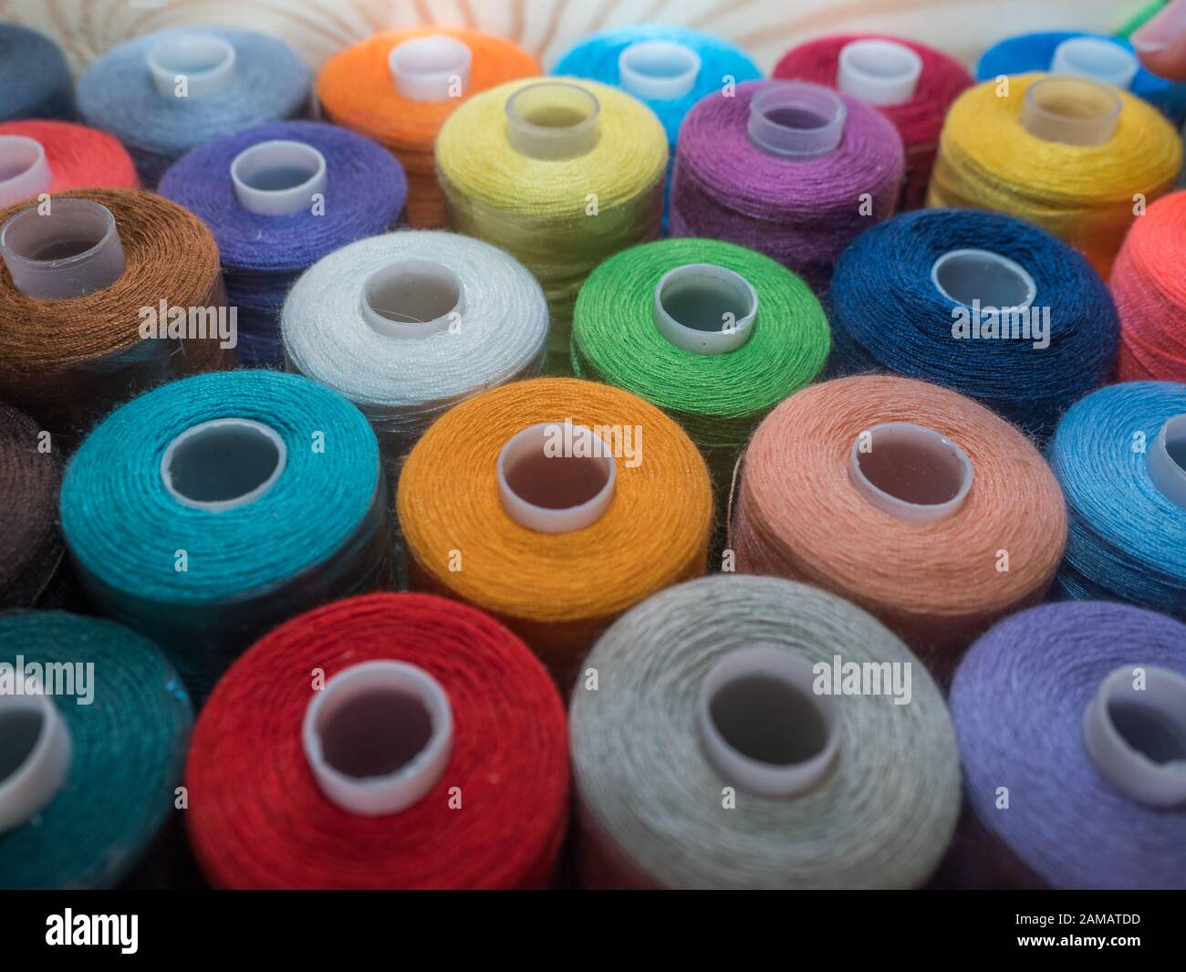 A lot of sewing colored thread. Thread reels. Colorful threads in the ...