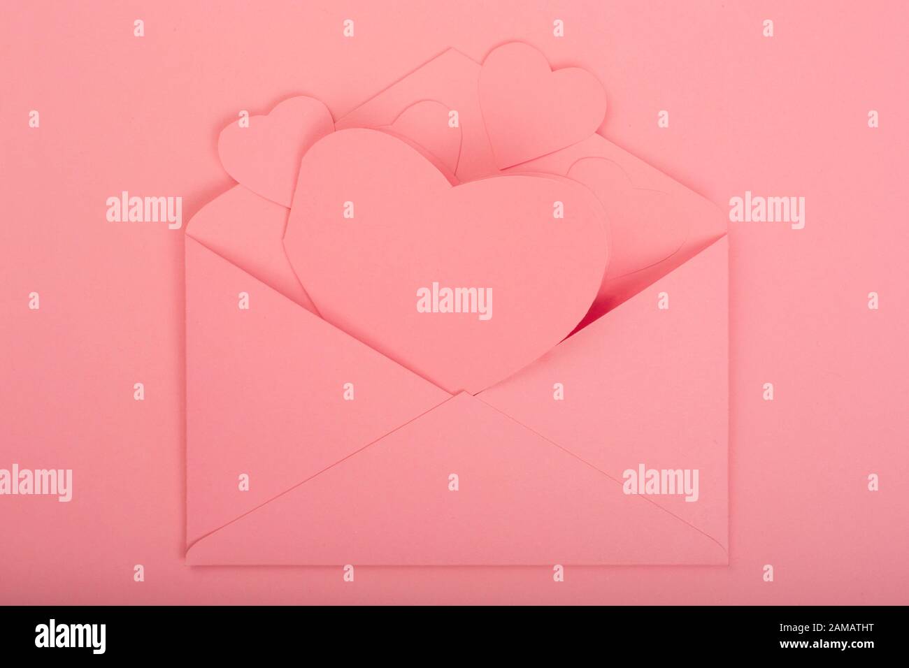Pink love letter and paper hearts on pink background with copy space ...