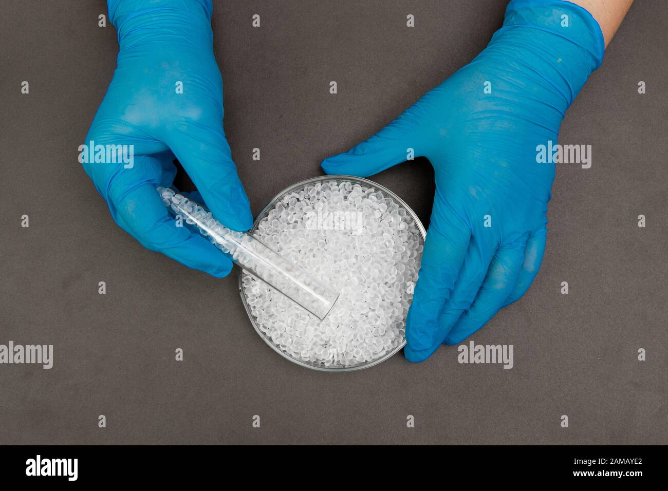 Plastic granules . Polyethylene pellets and hands with gloves. Quality ...