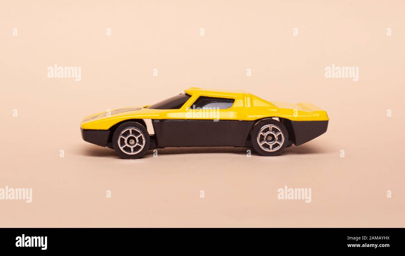 yellow little car. toy car on a beige background side view Stock Photo ...