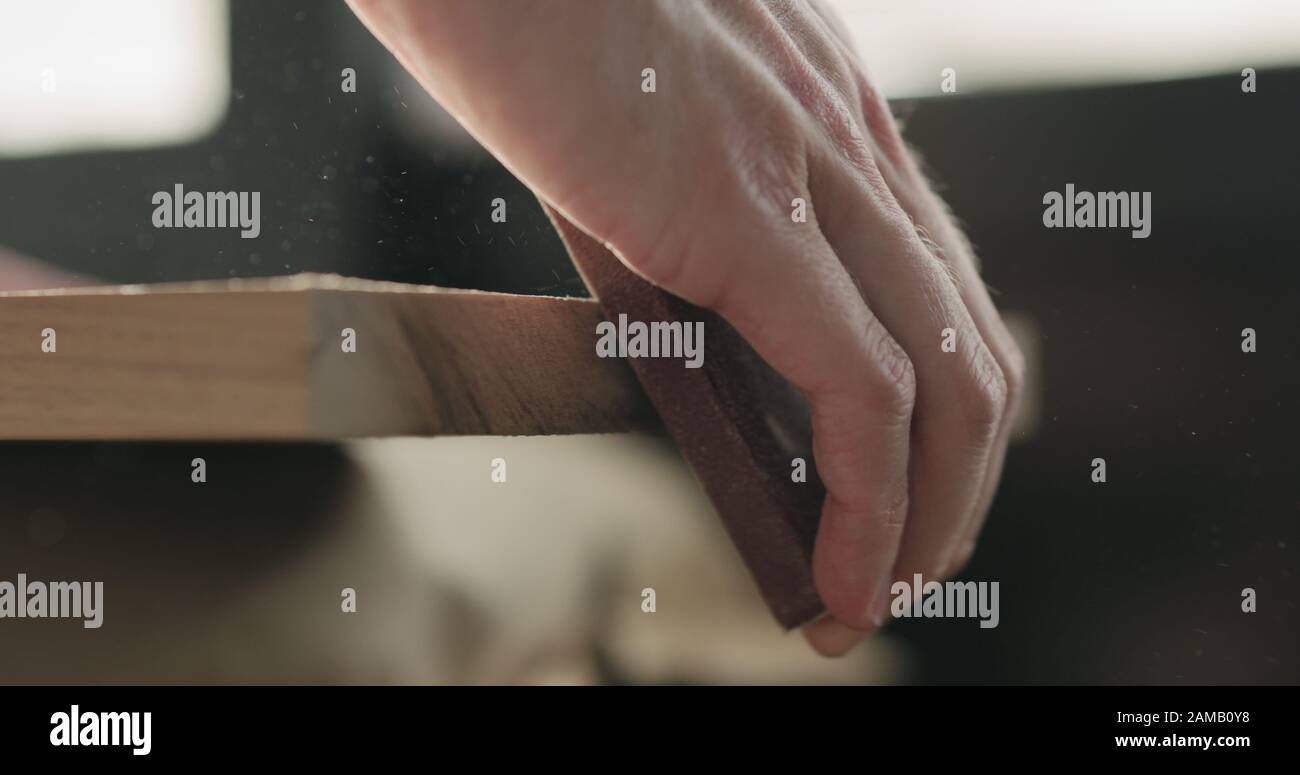 woodworker hand sanding walnut board with sand block, wide photo Stock ...