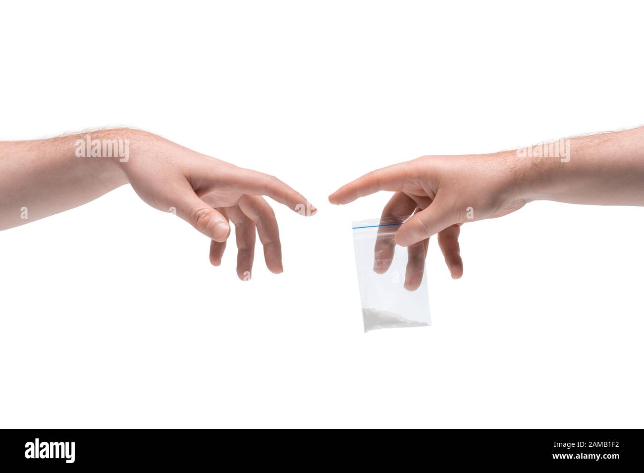 Two male hands passing one another small packet with drugs on white ...