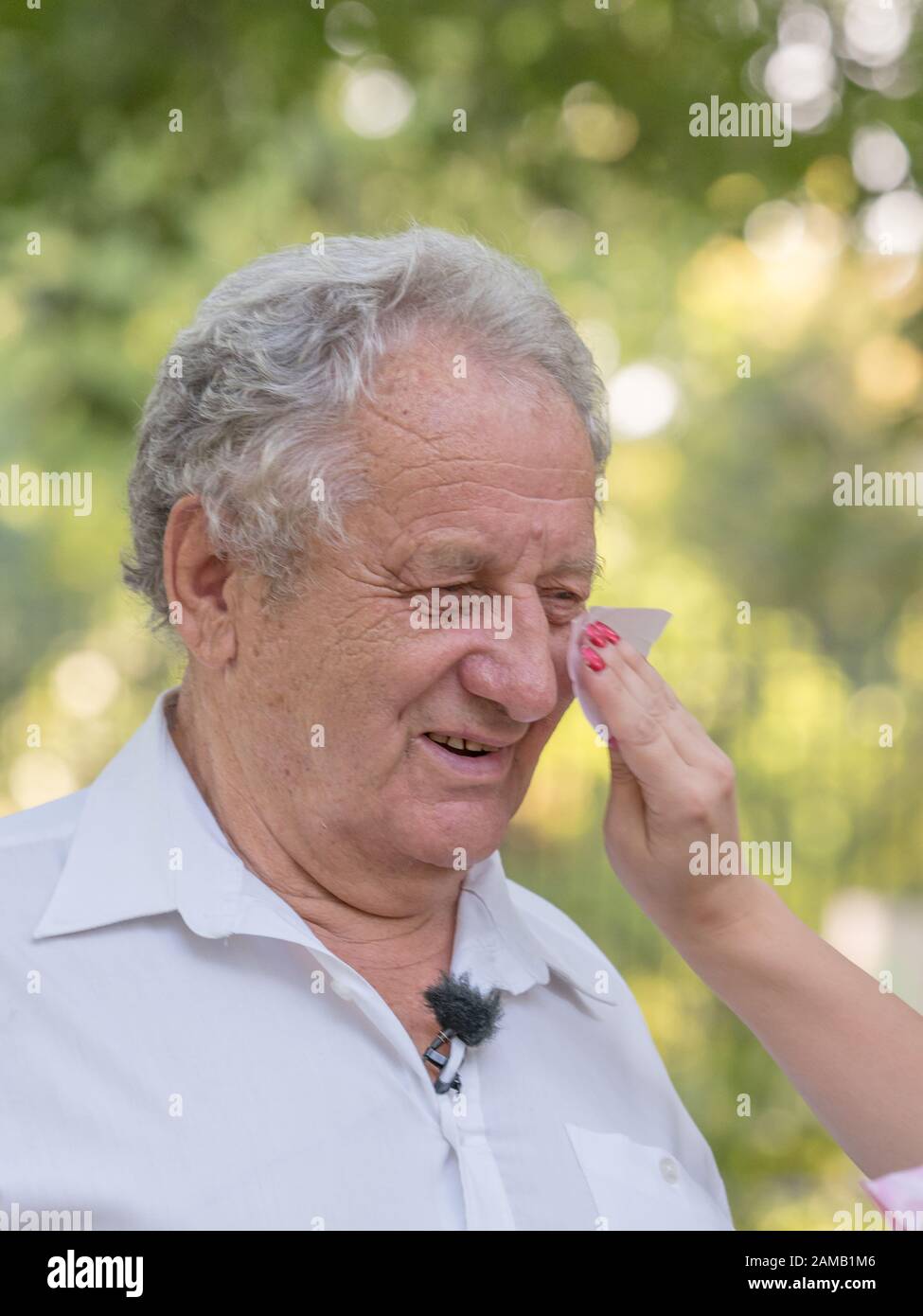 Powder applied to the face of older man before recording the film Stock ...
