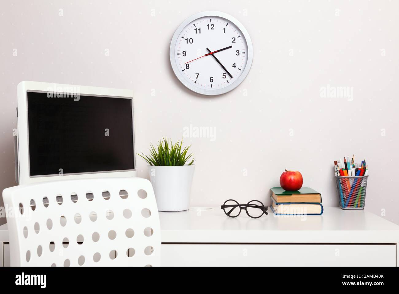 Student workplace. Closeup desk chair computer clock stack of books ...