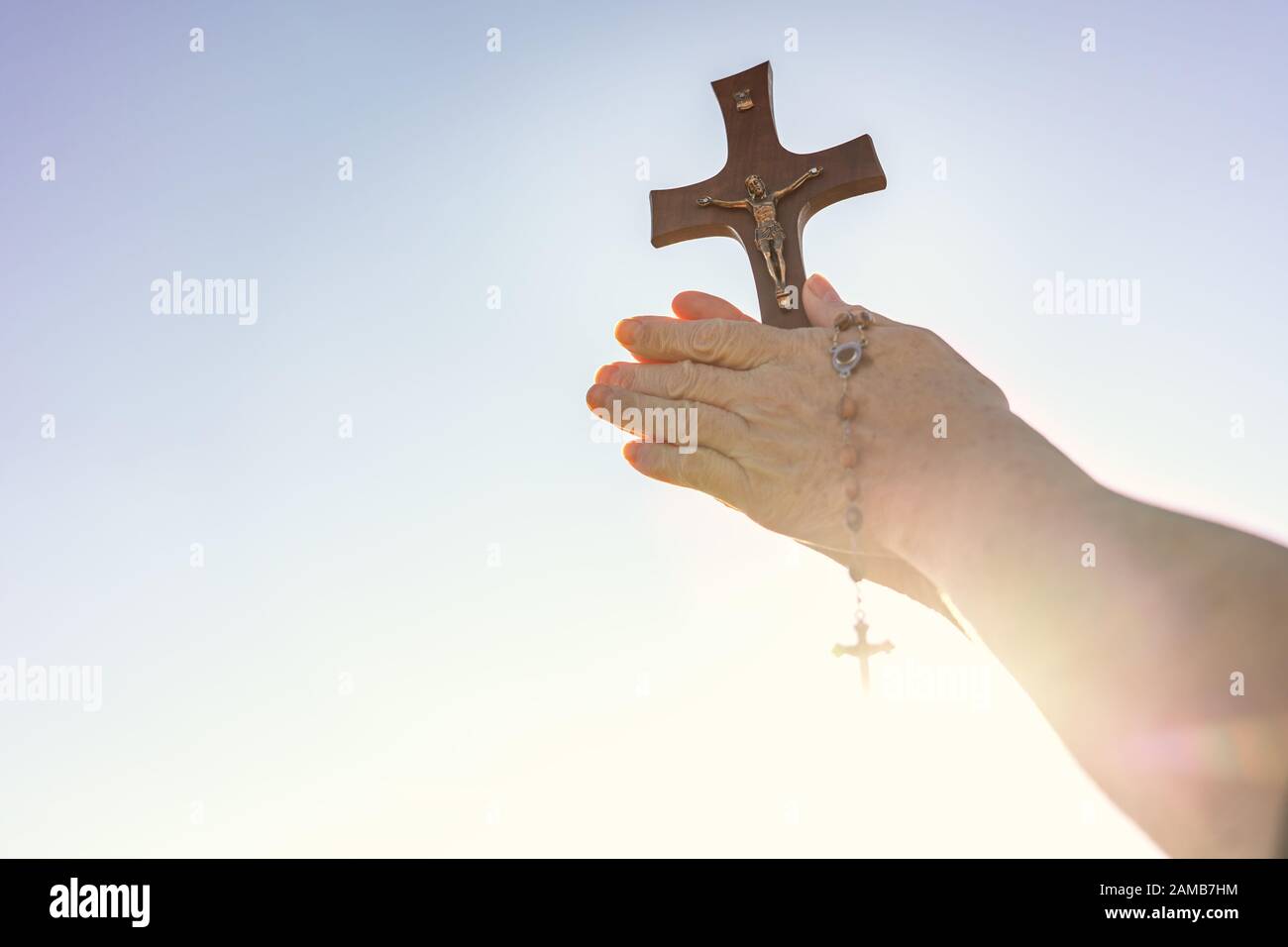 Woman praying outdoor with a crucifix with blinding sun light Stock ...