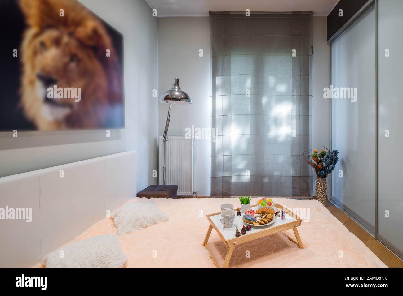 Simple interior of modern bedroom. Tray with food on the bed. Romantic ...