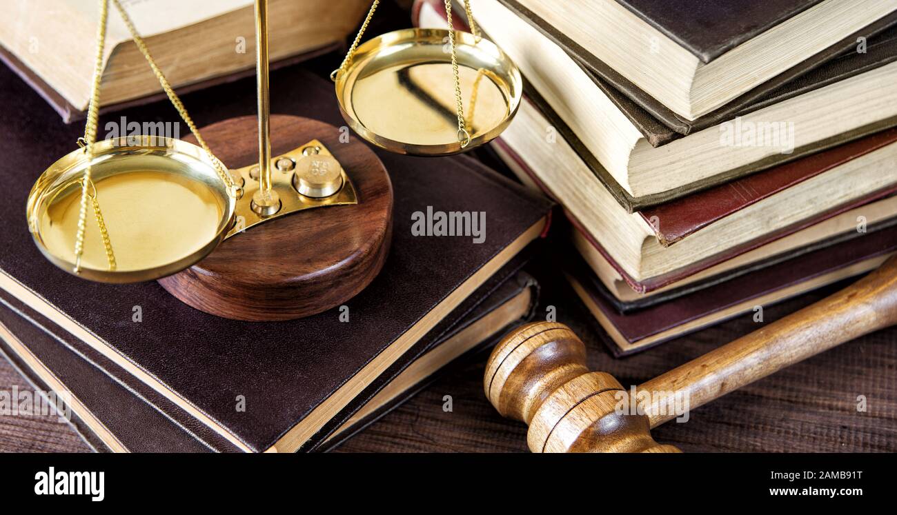 Wood gavel, soundblock, scales and stack of old books against the ...