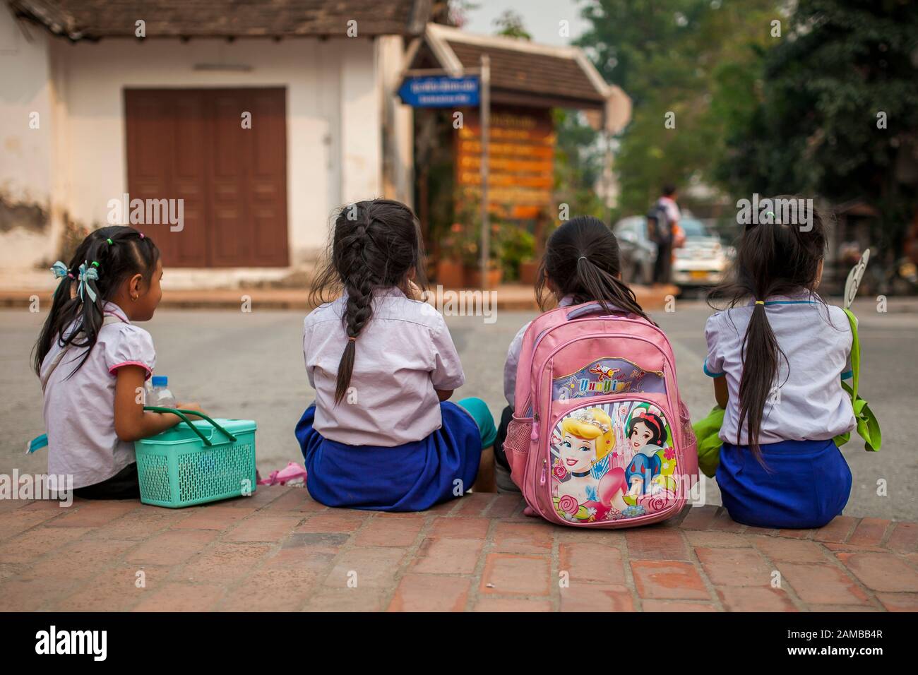 Luang Prabang, Laos - April 10, 2013: Four school girls sitting on the ...