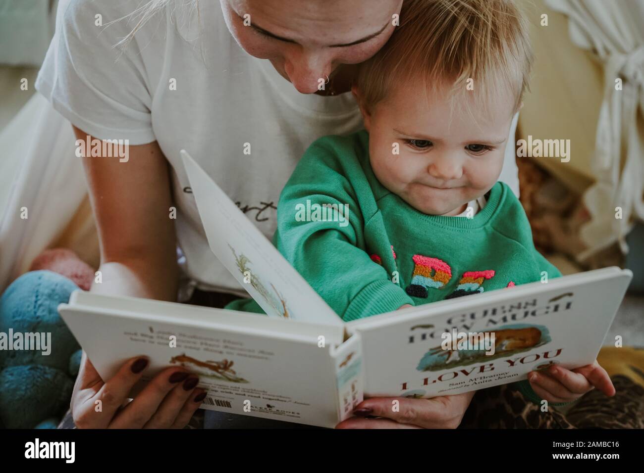 Young child reading with their mum Stock Photo - Alamy