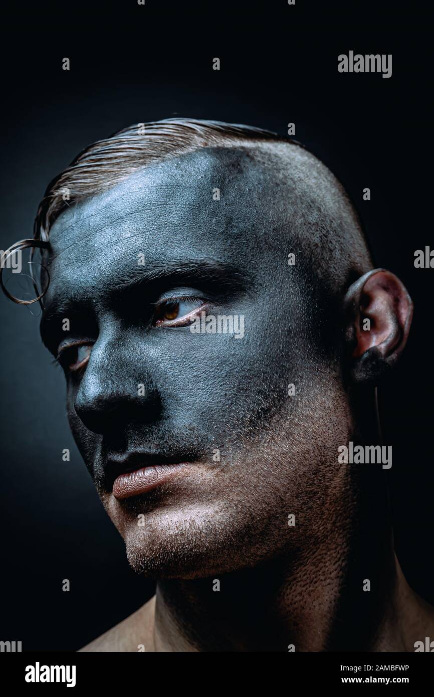 The dirty face of a working miner. Close-up portrait of a black face in ...
