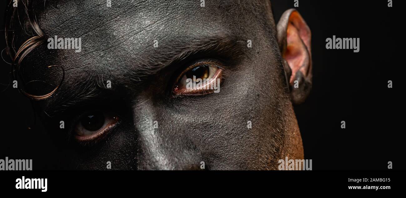 The dirty face of a working miner. Close-up portrait of a black face in ...
