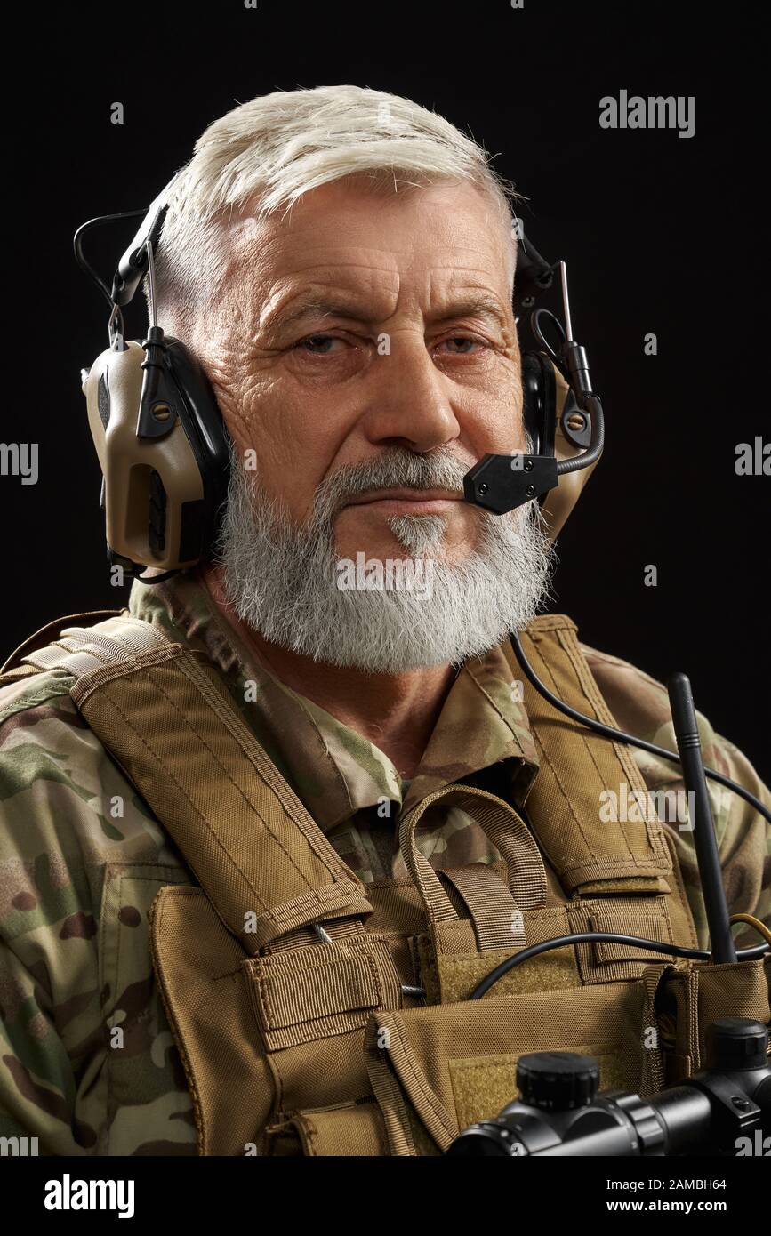 Front view of old military officer with ear protection looking at ...