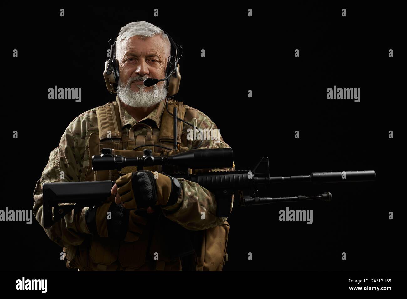 Front view of old military officer with ear protection holding sniper ...