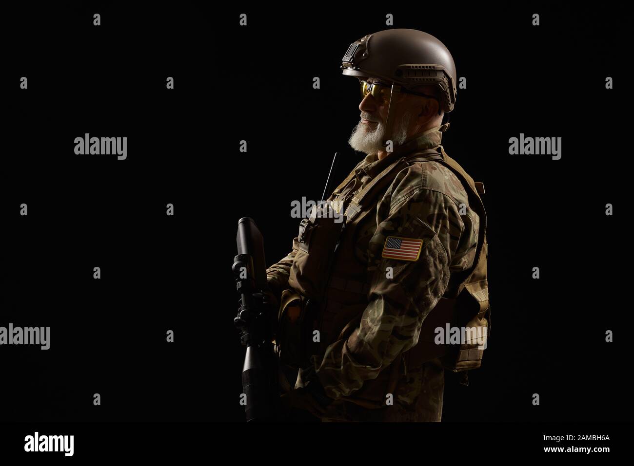 Side view of old smiling military officer holding sniper rifle and ...