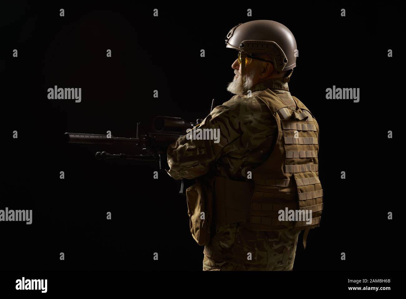 Side view of old military officer holding sniper rifle on elbow and ...