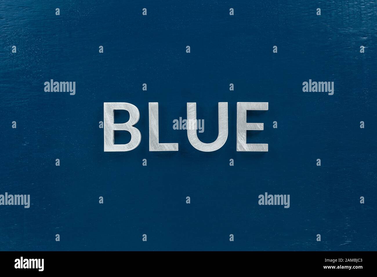 the word blue laid with silver metal letters on classic blue painted ...