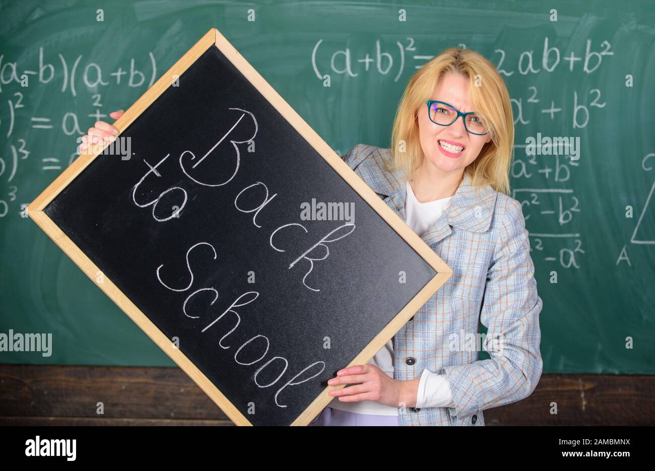 Woman teacher formal suit holds blackboard inscription back to school ...