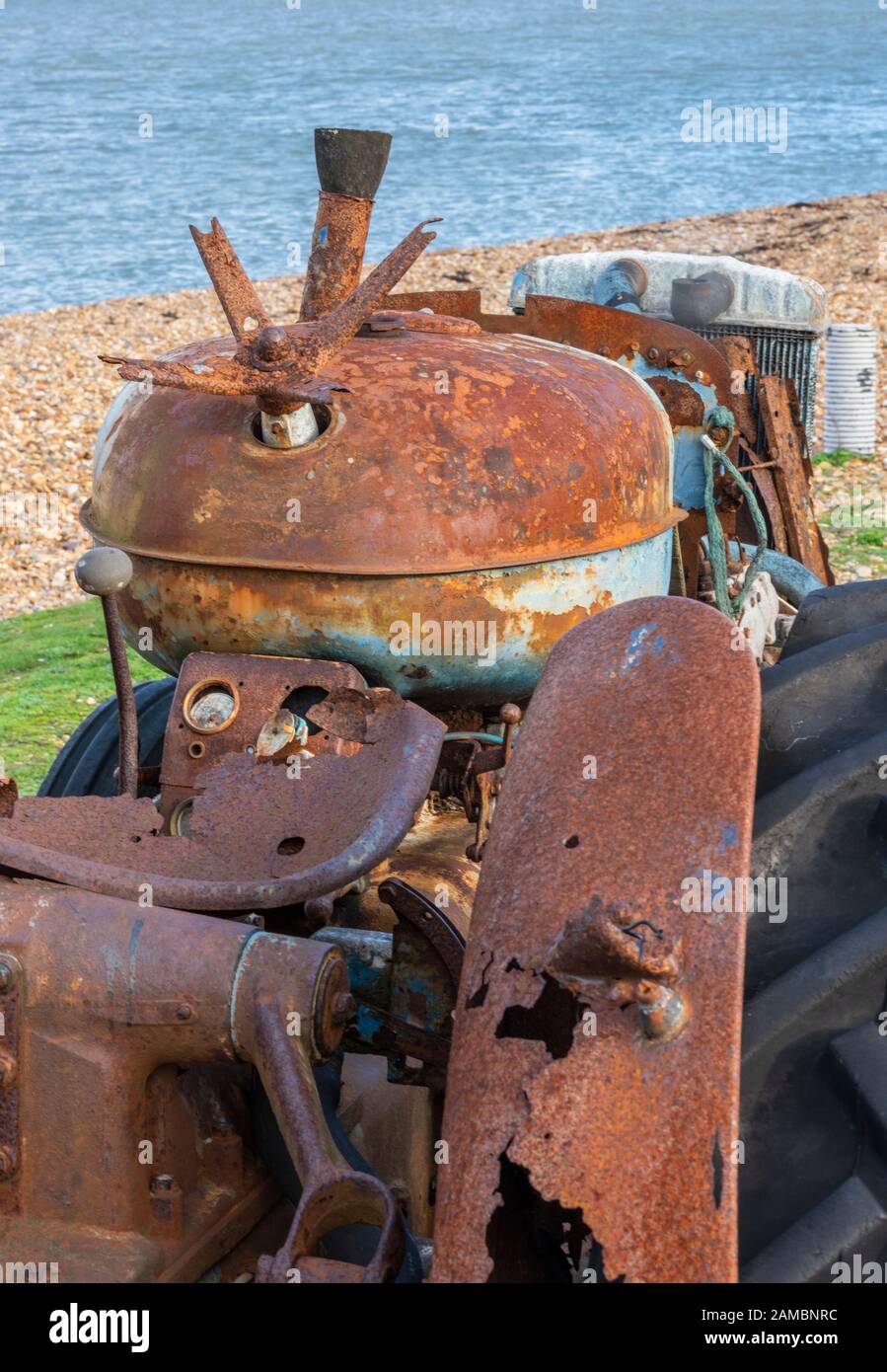 An old derelict tractor engine corroded and rusting on a beach Stock ...
